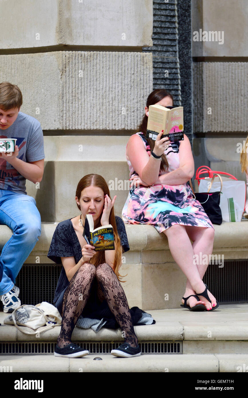 London, England, UK. Women reading books in Paternoster Square, behind ...