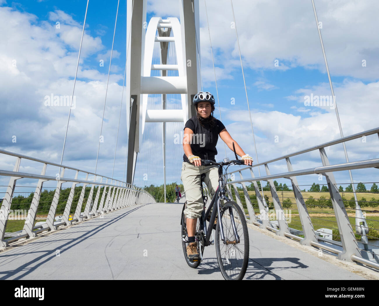 Female cyclist on the Infinity Bridge spanning the river Tees at ...