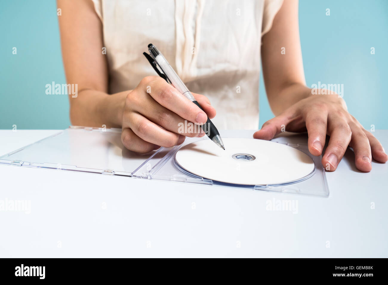 Woman writing on DVD-ROM Stock Photo - Alamy