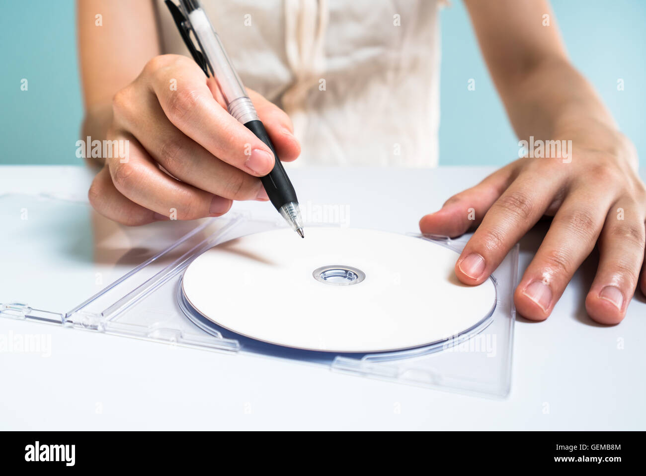 Woman writing on DVD-ROM Stock Photo - Alamy