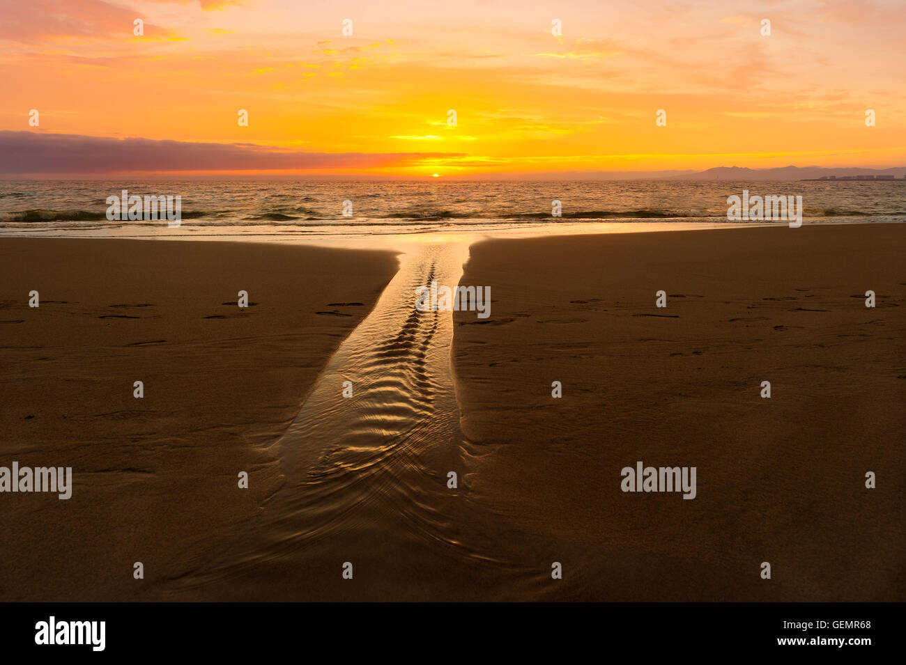 Ocean sunset is a sandy beach scenic with a soft flowing stream and a ...