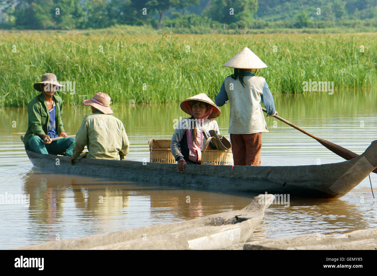 roup of Asian farmer go to work by row boat on Lak lake in summertime ...