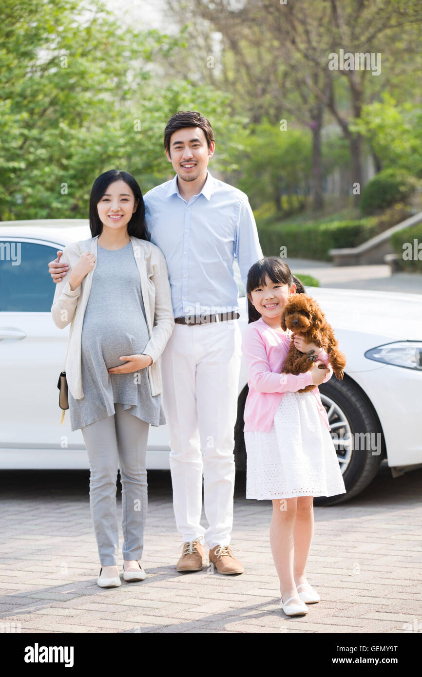 Young Chinese family getting out of car with their pet dog Stock Photo ...