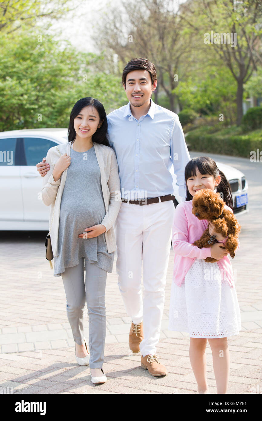 Young Chinese family getting out of car with their pet dog Stock Photo ...
