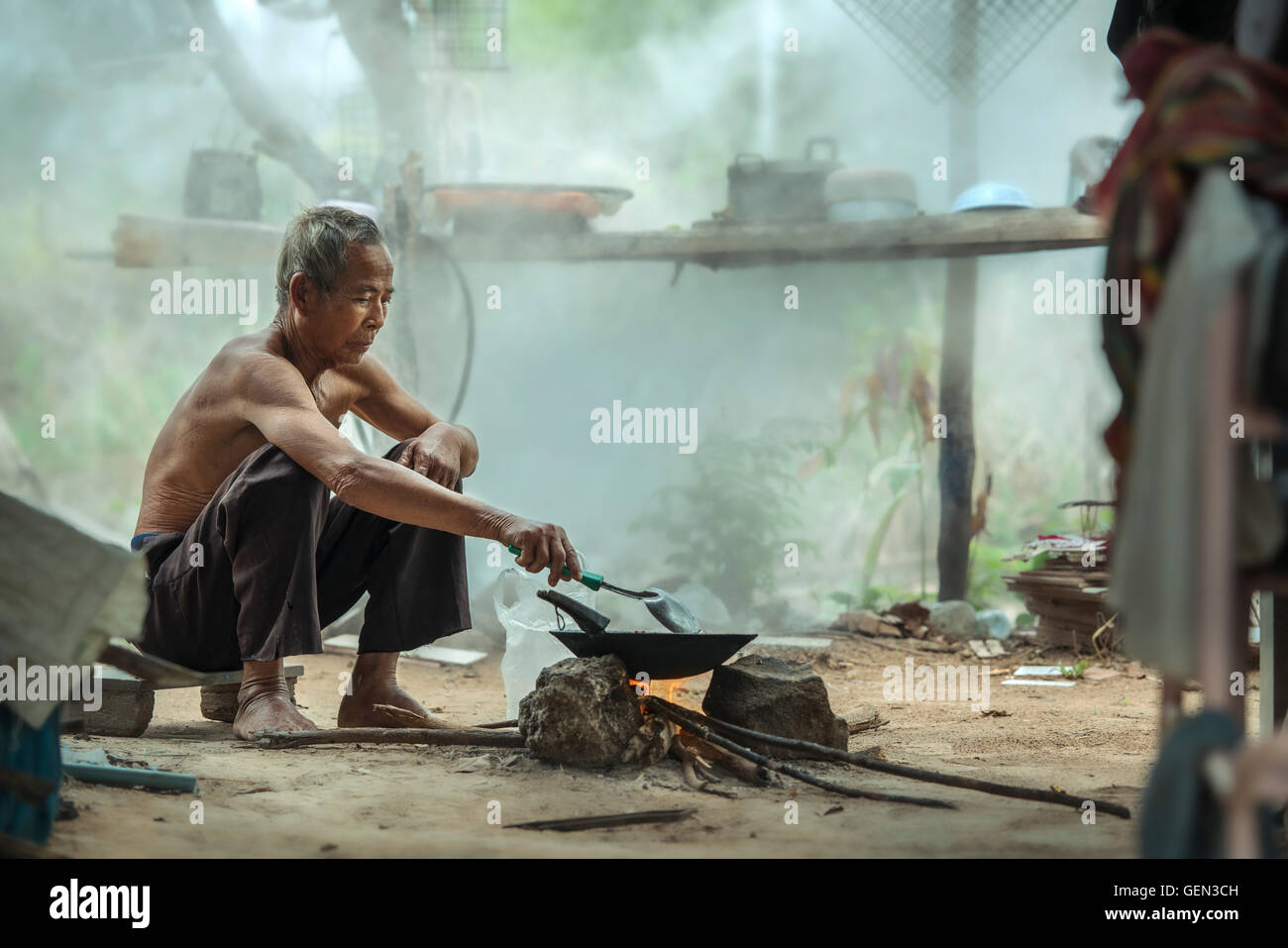 Old man sitting and cooking outside his home Stock Photo - Alamy