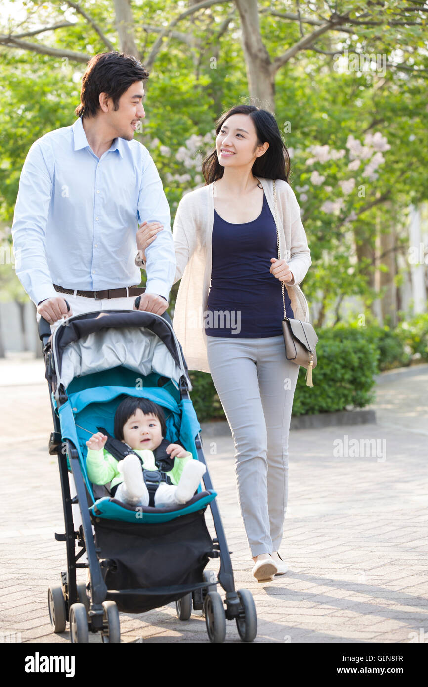 Young Chinese couple taking a walk with their baby in pram Stock Photo ...