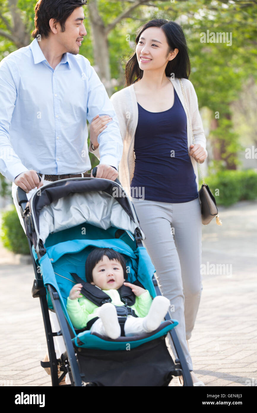 Young Chinese couple taking a walk with their baby in pram Stock Photo ...