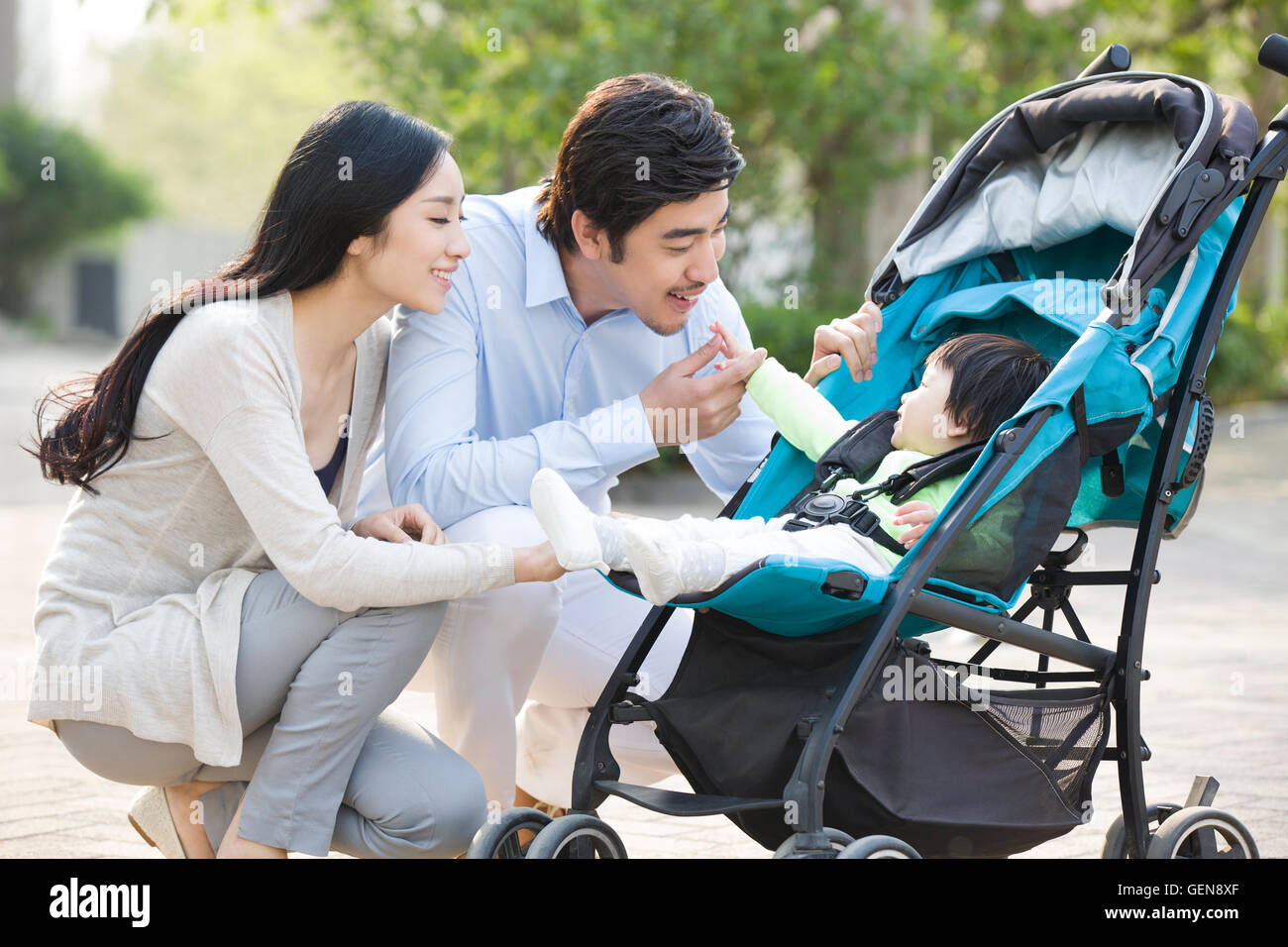 Young Chinese couple and their baby in pram Stock Photo - Alamy