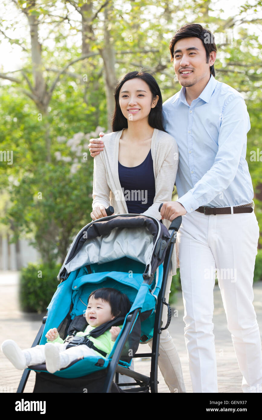 Young Chinese couple taking a walk with their baby in pram Stock Photo ...