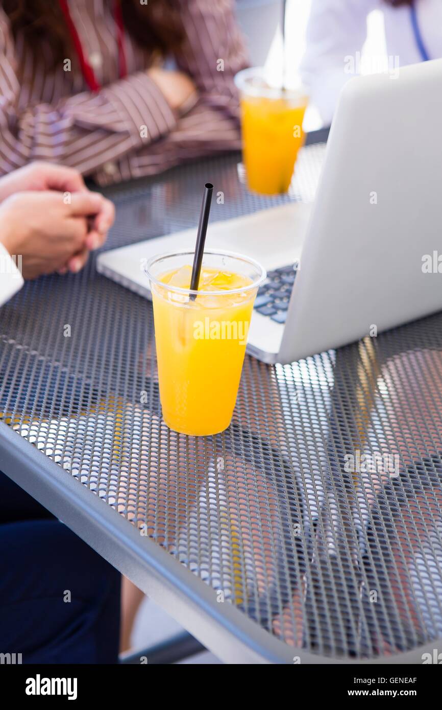 A laptop and a glass of juice at outdoor seat Stock Photo - Alamy