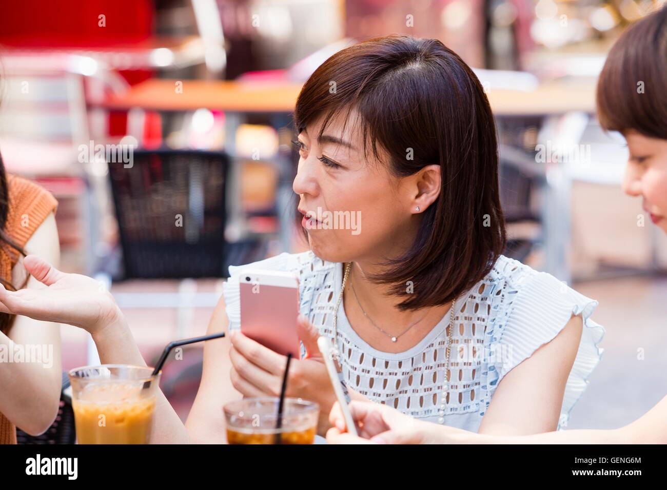 Business women operating their smart phone at an outdoor cafe Stock ...
