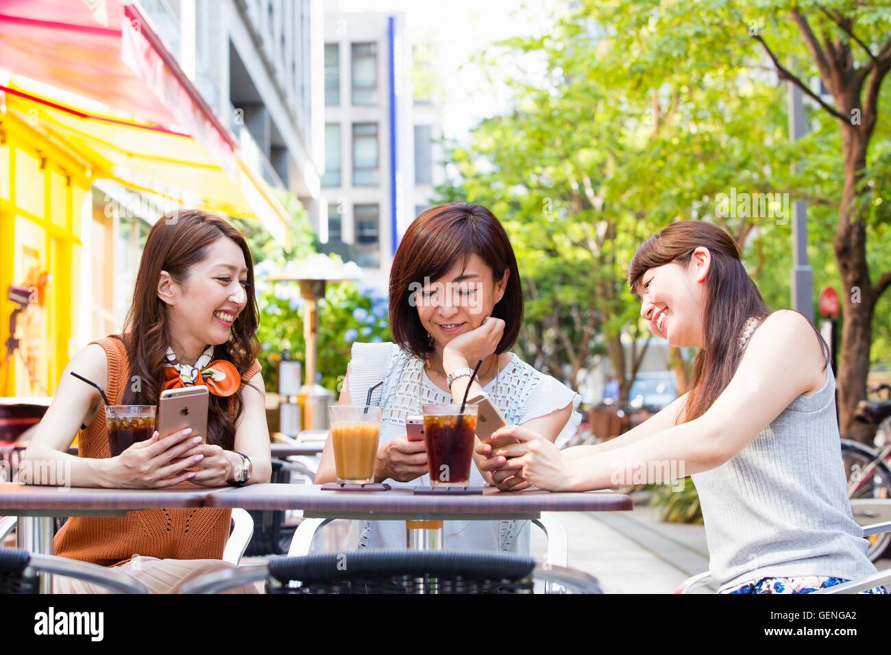 Business women operating their smart phone at an outdoor cafe Stock ...