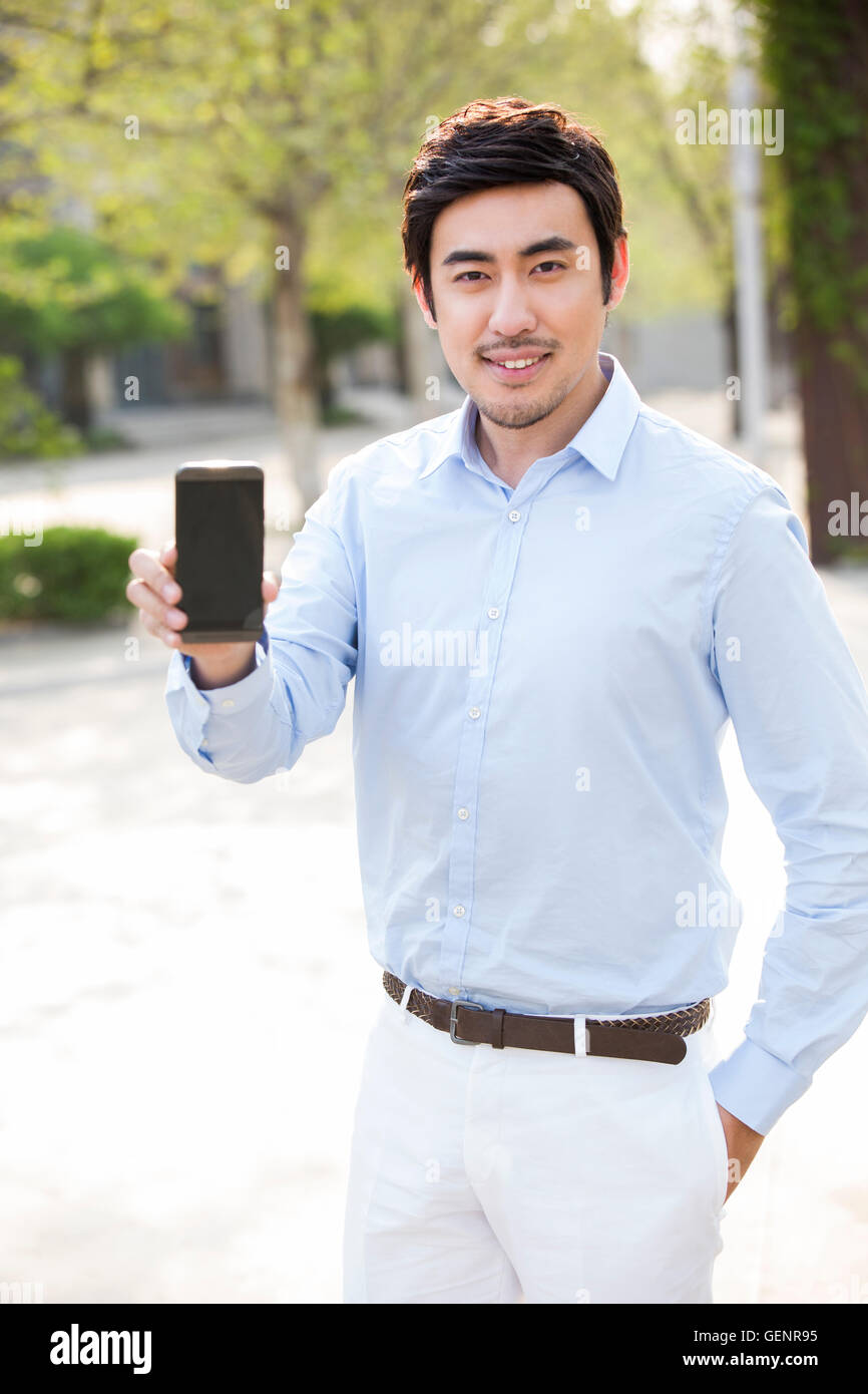 Young Chinese man showing a smart phone Stock Photo - Alamy