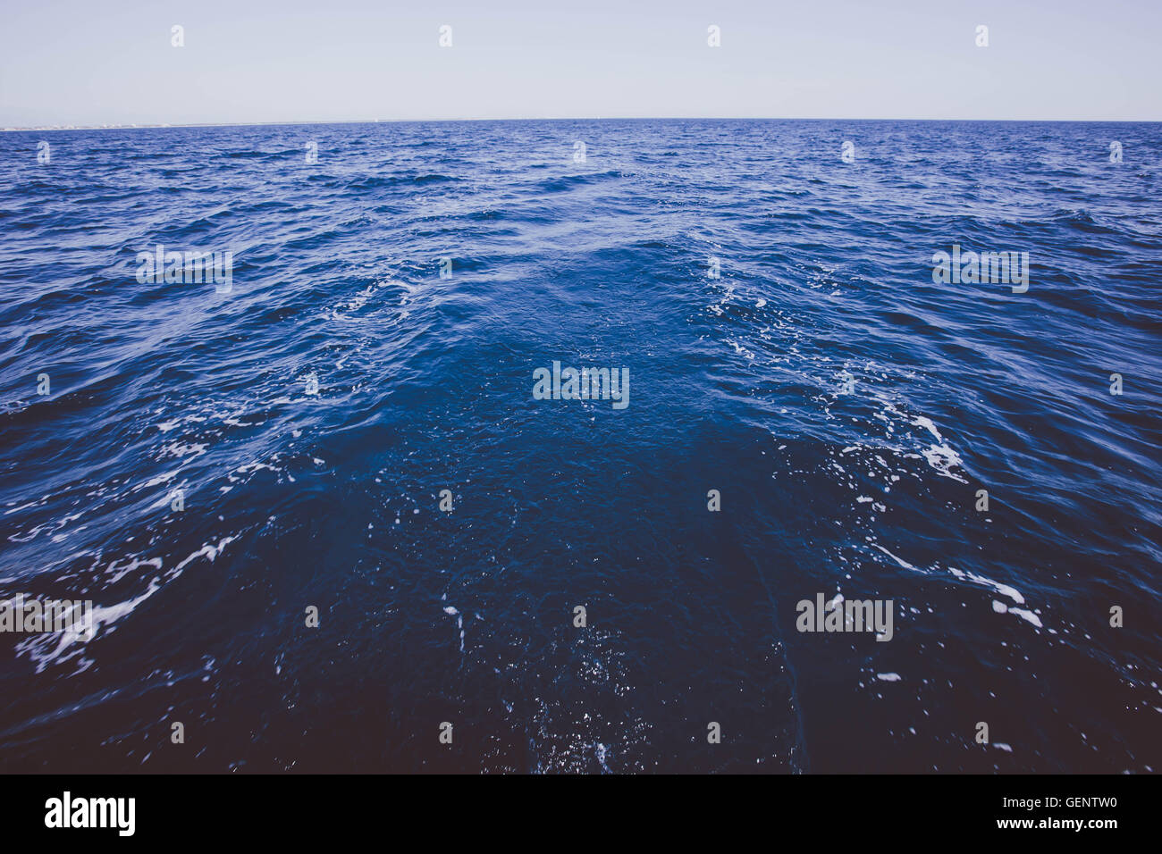 Sea horizon with a sailing boat in the scene, the deep blue sea of ...