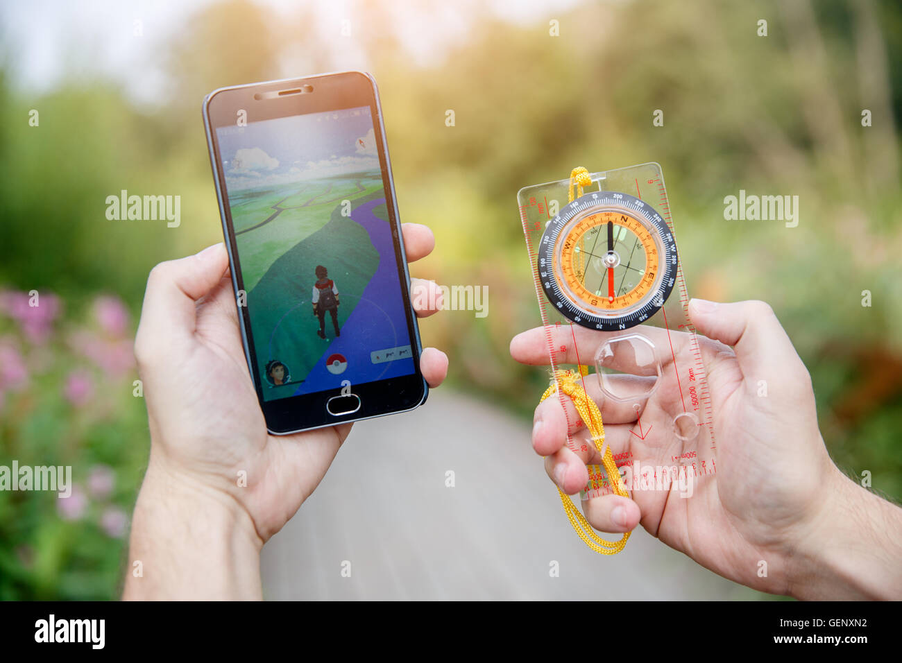 Man held in hands compas and phone showing its screen with Pokemon Go ...