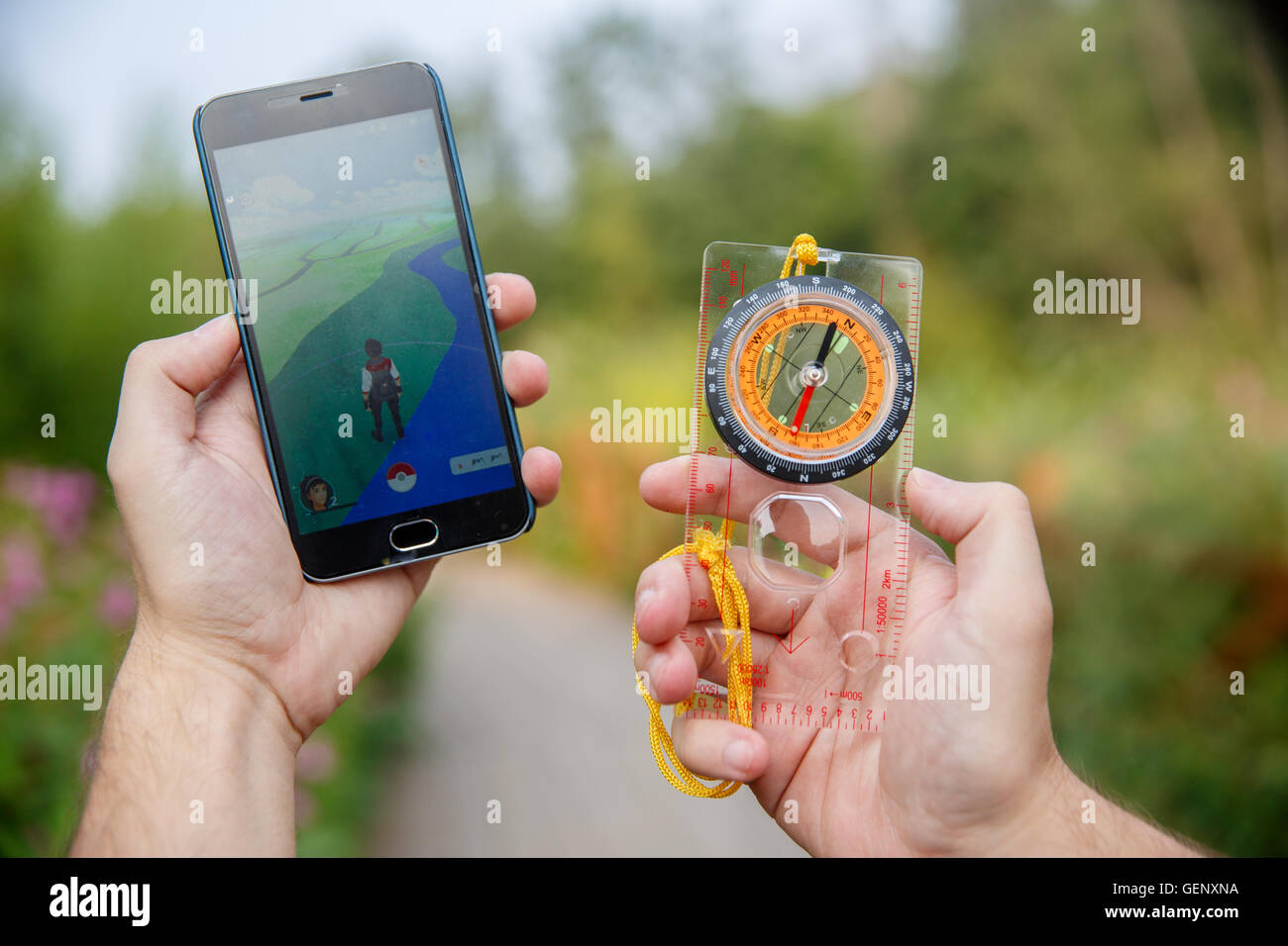 Man held in hands compas and phone showing its screen with Pokemon Go ...