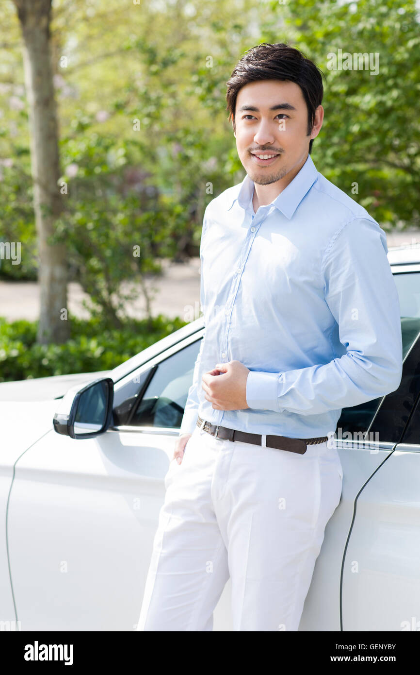 Young Chinese man leaning on car Stock Photo - Alamy