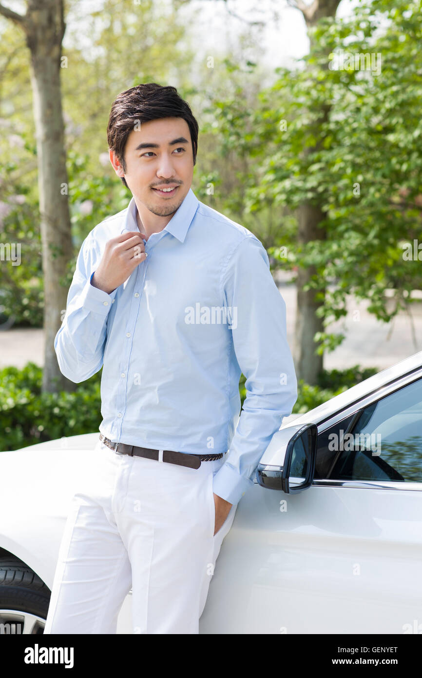 Young Chinese man leaning on car Stock Photo - Alamy
