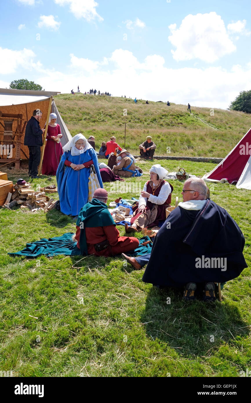 People dressed in medieval robes have picnic on lawn. Re-enactment ...