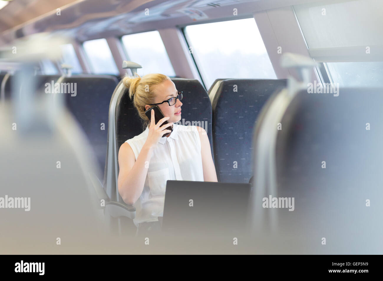 Business woman working while travelling by train Stock Photo - Alamy