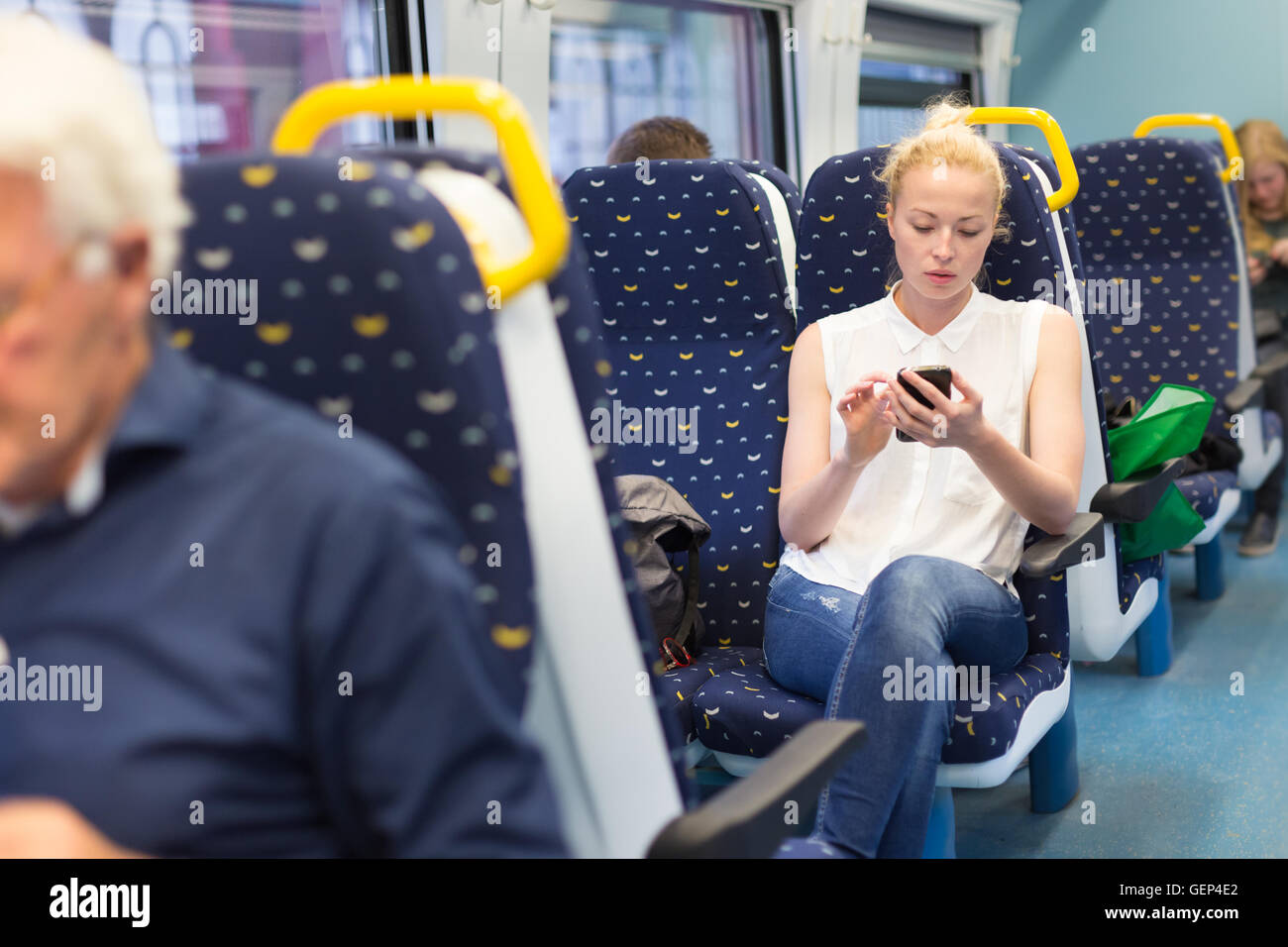 Woman sitting underground train using cell phone hi-res stock ...