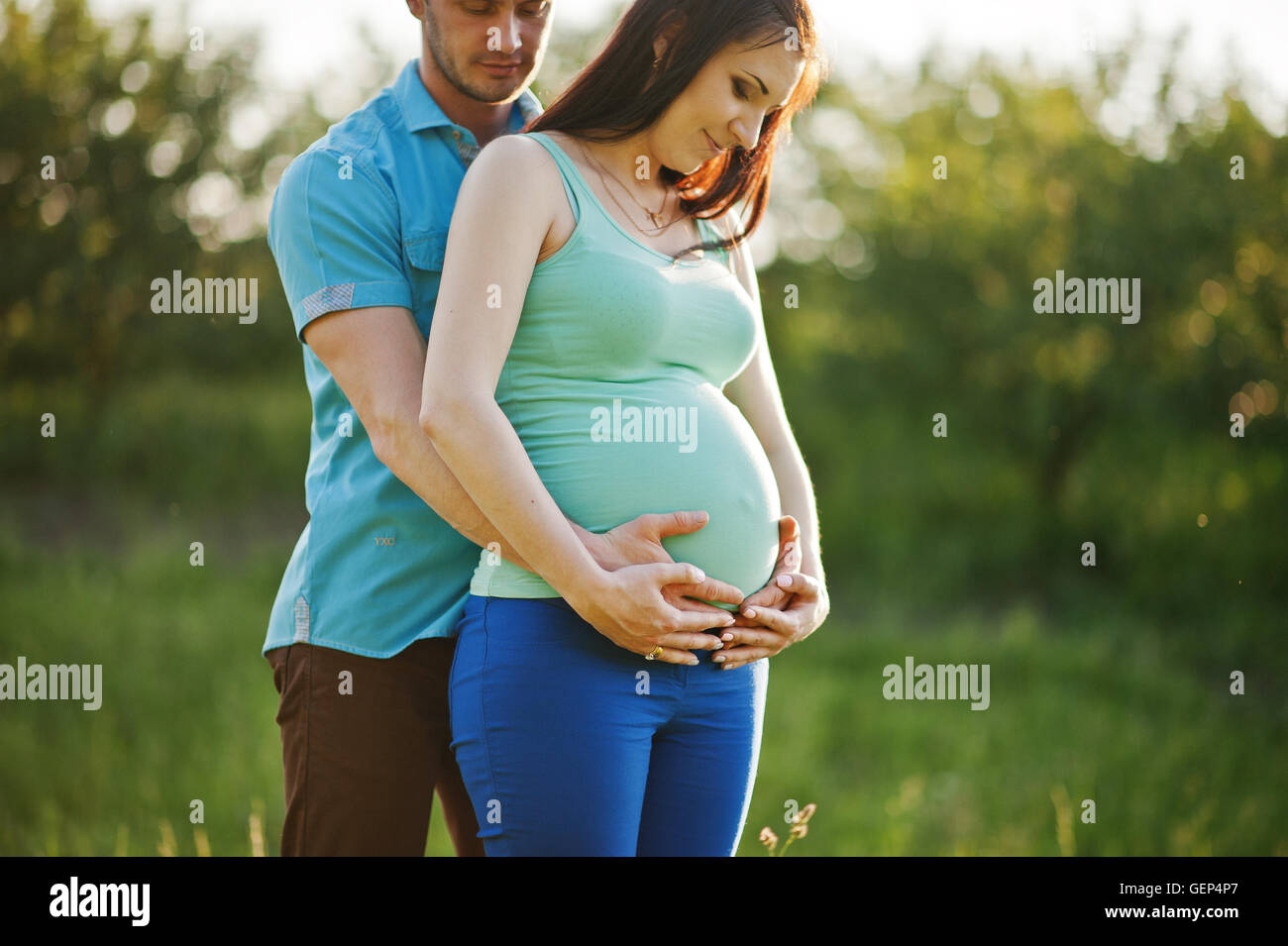 Happy pregnant couple at garden on magestic sunset Stock Photo - Alamy