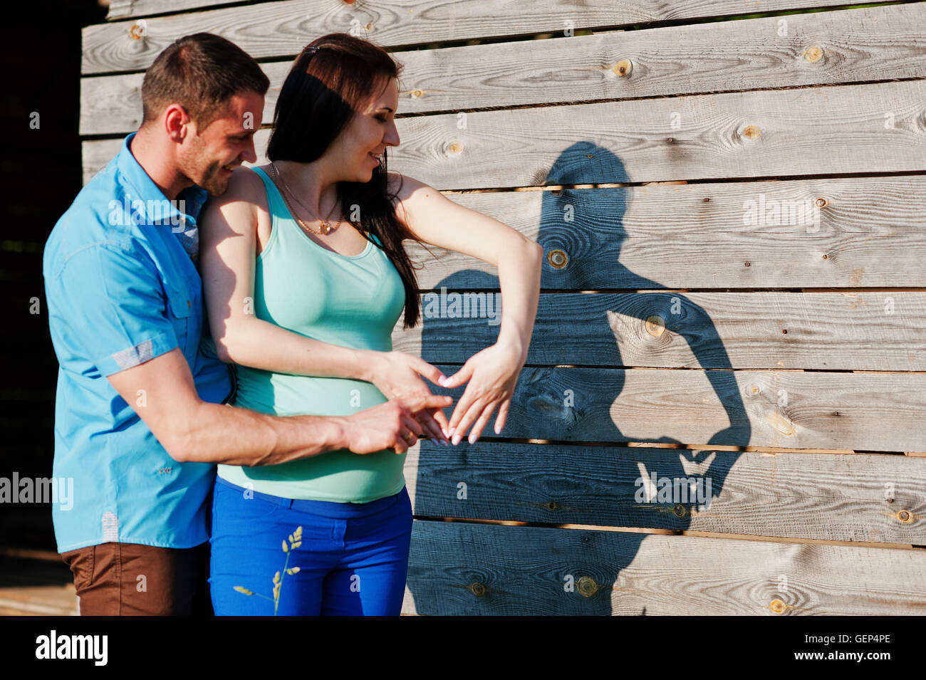 Pregnant couple showing shadow heart with fingers Stock Photo - Alamy