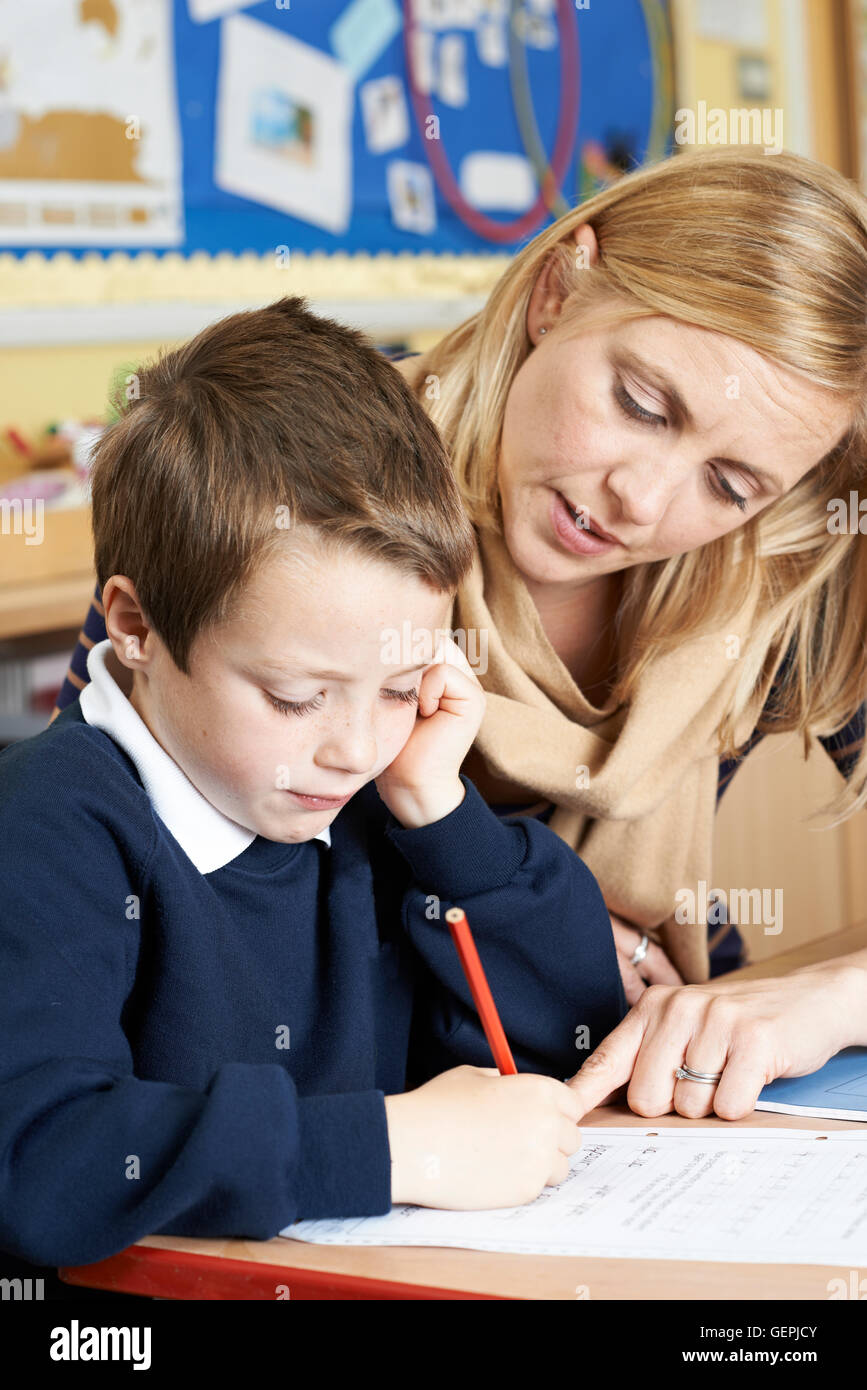Teacher With Male Elementary School Pupil With Problem Stock Photo - Alamy