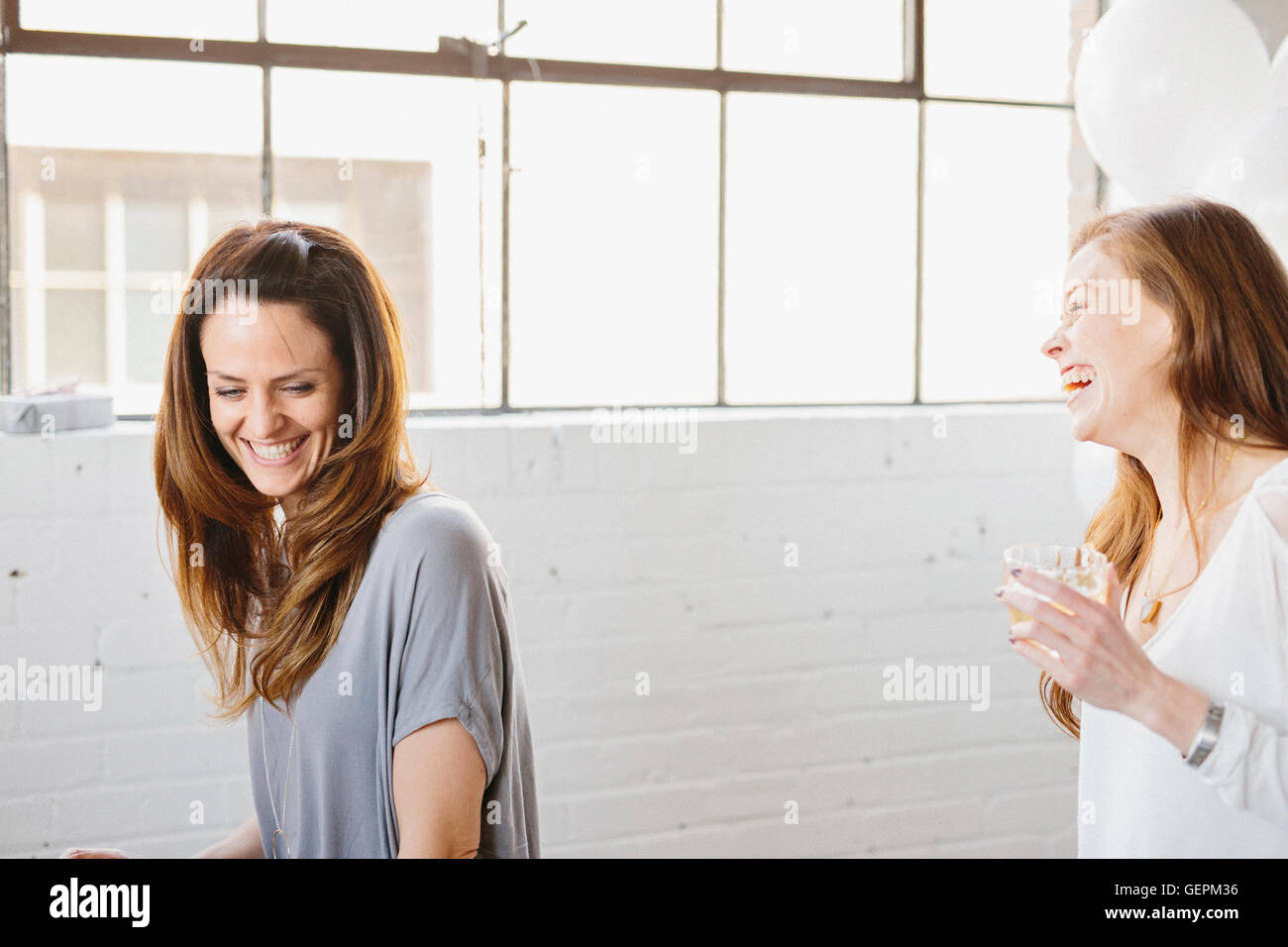Two women laughing together Stock Photo - Alamy