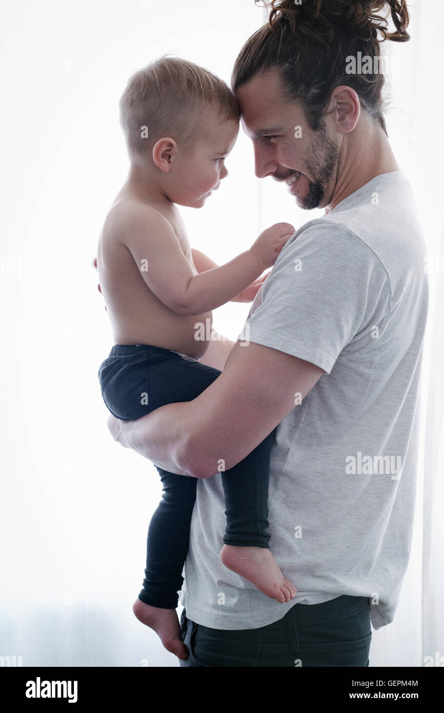 A young man holding a small child in his arms Stock Photo - Alamy