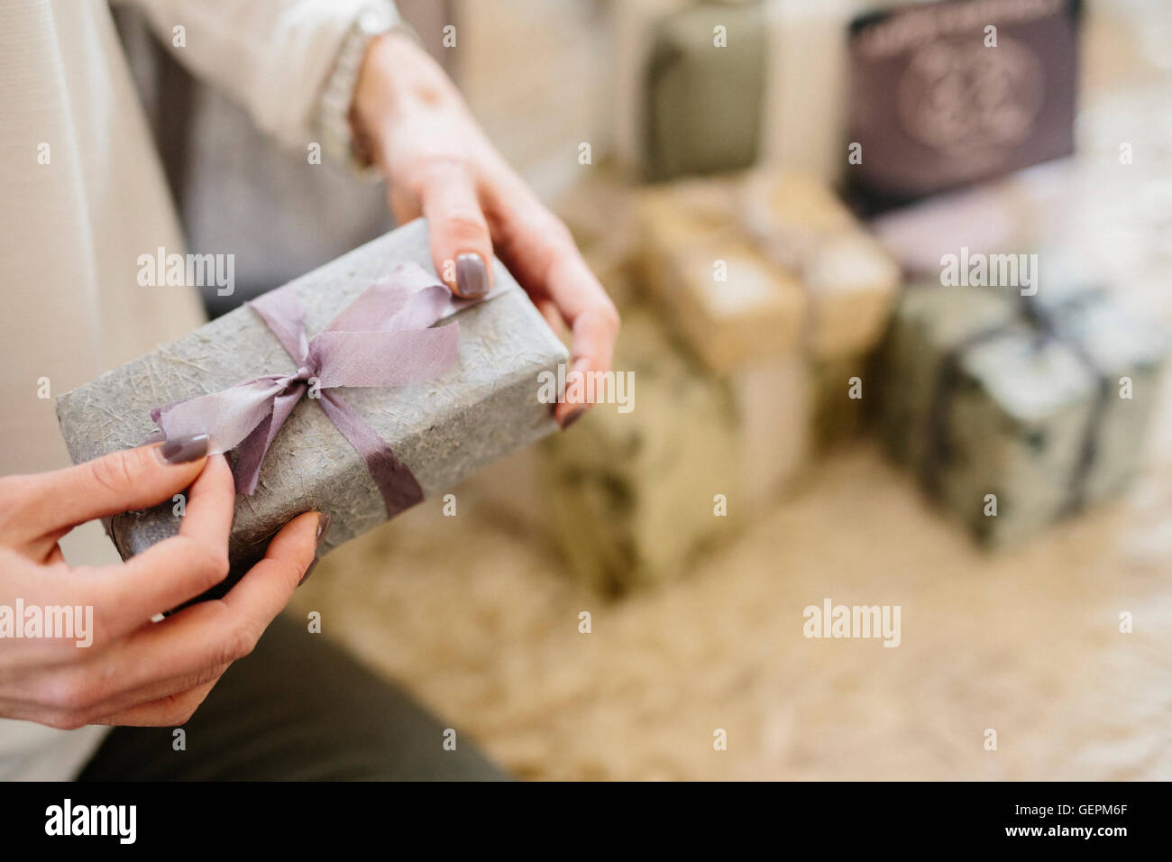 A woman holding a gift wrapped present Stock Photo - Alamy