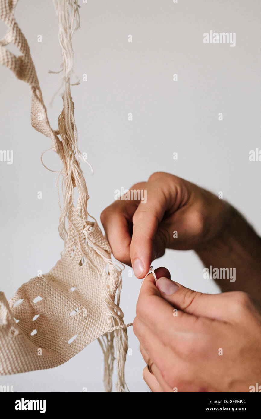 An artist working on an art piece, creating an object with thread Stock ...