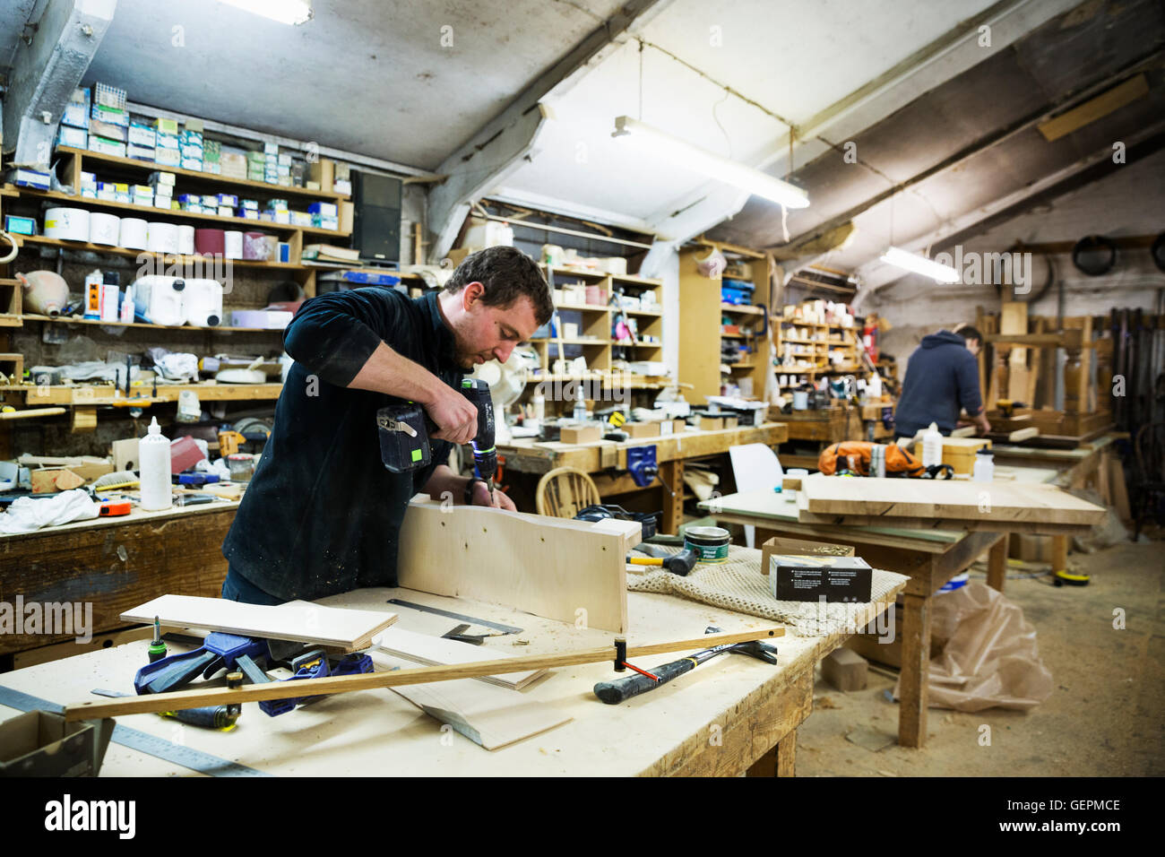 Man standing at a work bench in a carpentry workshop, working on a ...