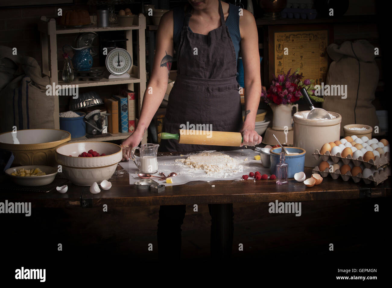 Valentine's Day baking, woman standing in a kitchen, rolling out dough ...