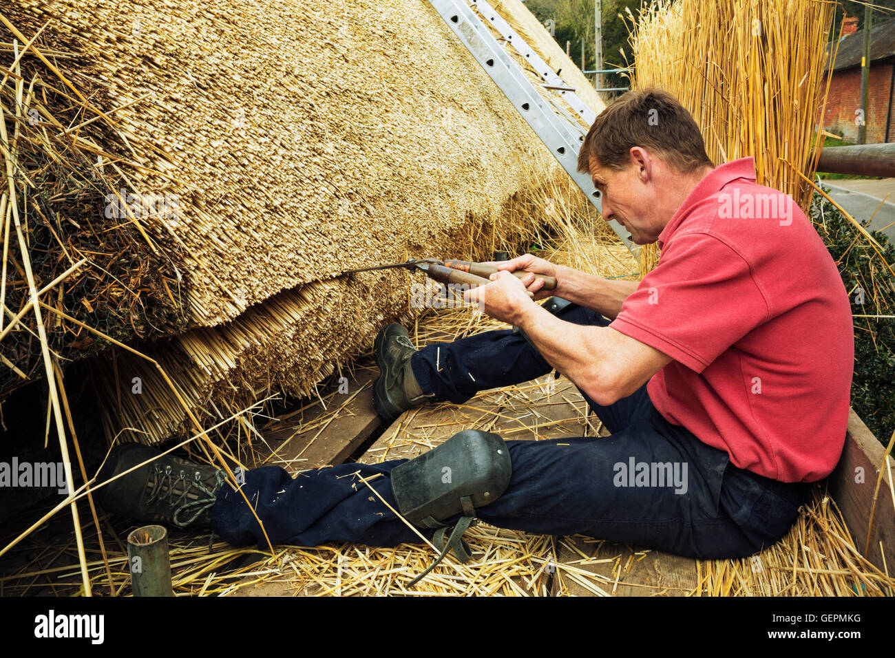 Thatcher trimming straw of a thatched roof with shears Stock Photo - Alamy