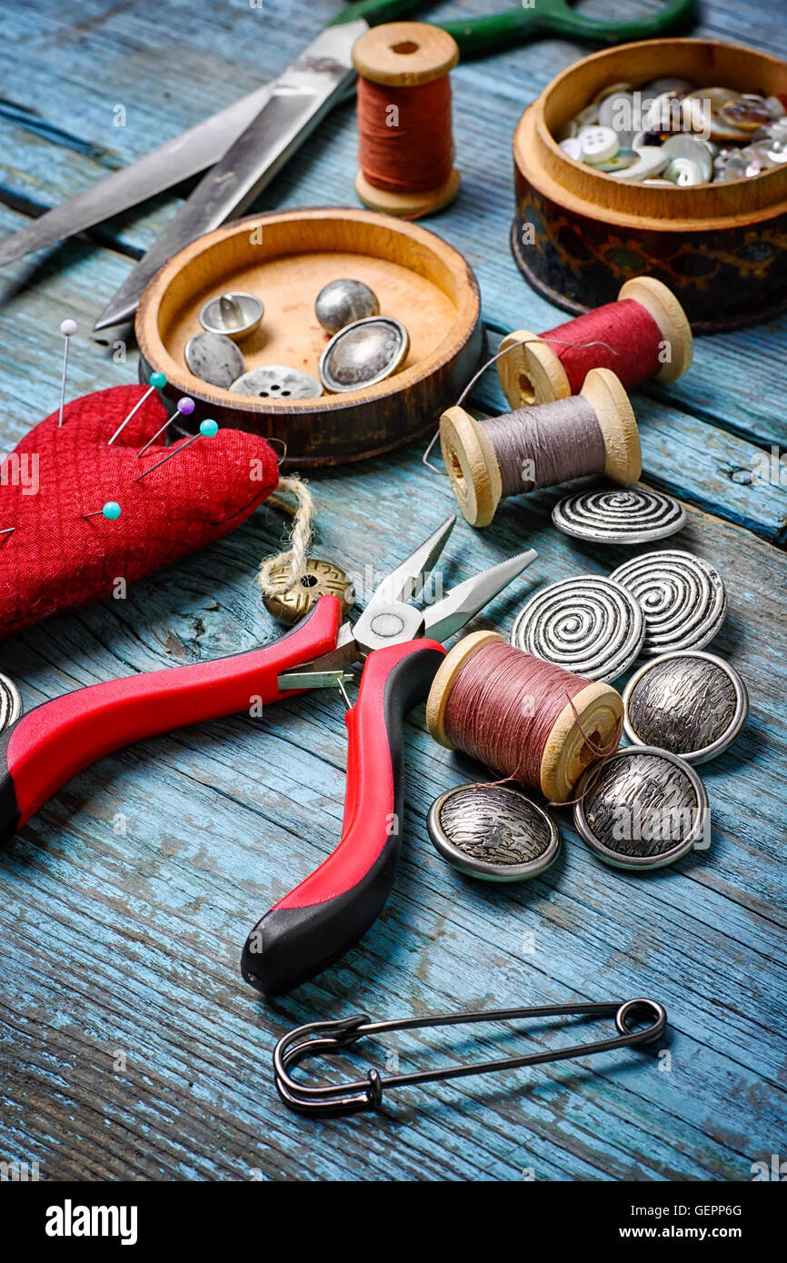 Scissors ,iron, stylish old-fashioned buttons and thread on wooden ...