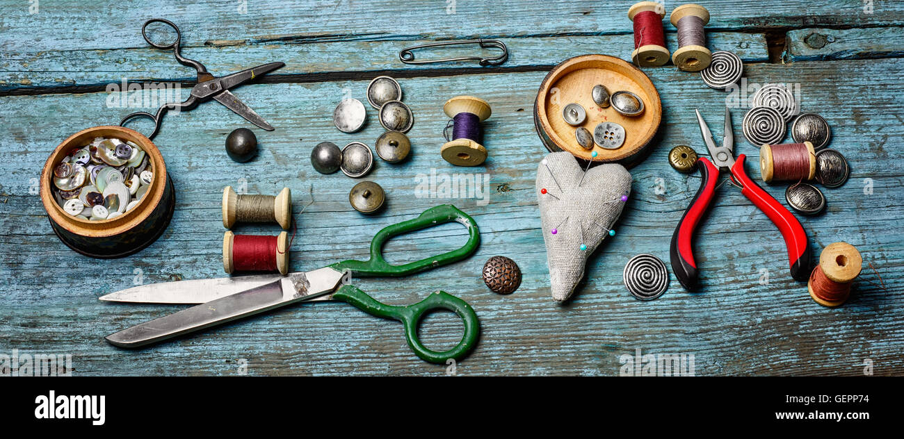 Sewing tools scissors,threads and buttons on old vintage background ...
