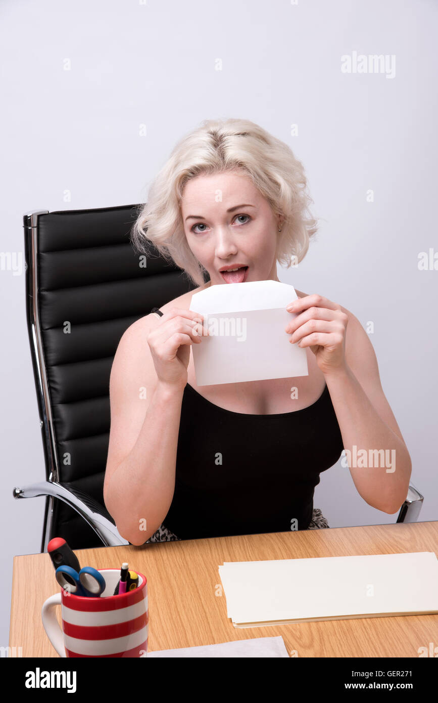 SECRETARY WORKING AT A DESK. Secretary licking an envelope Stock Photo ...