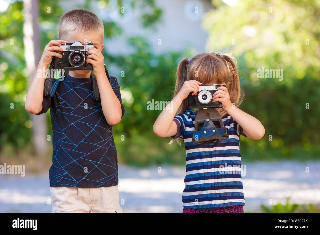 Little boy and girl learning how to use photo camera Stock Photo - Alamy