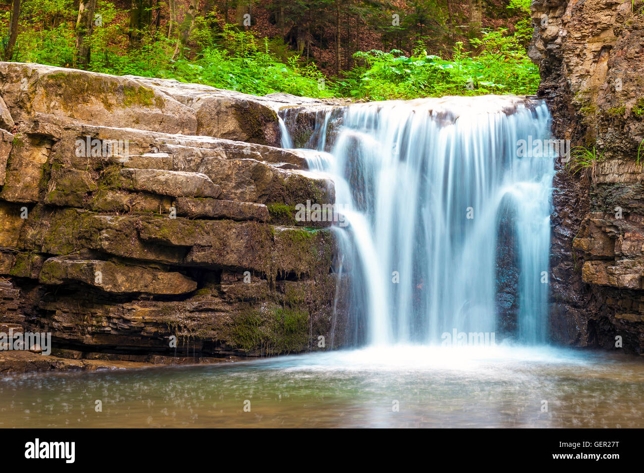 Little waterfall in mountain forest with silky foaming water Stock ...