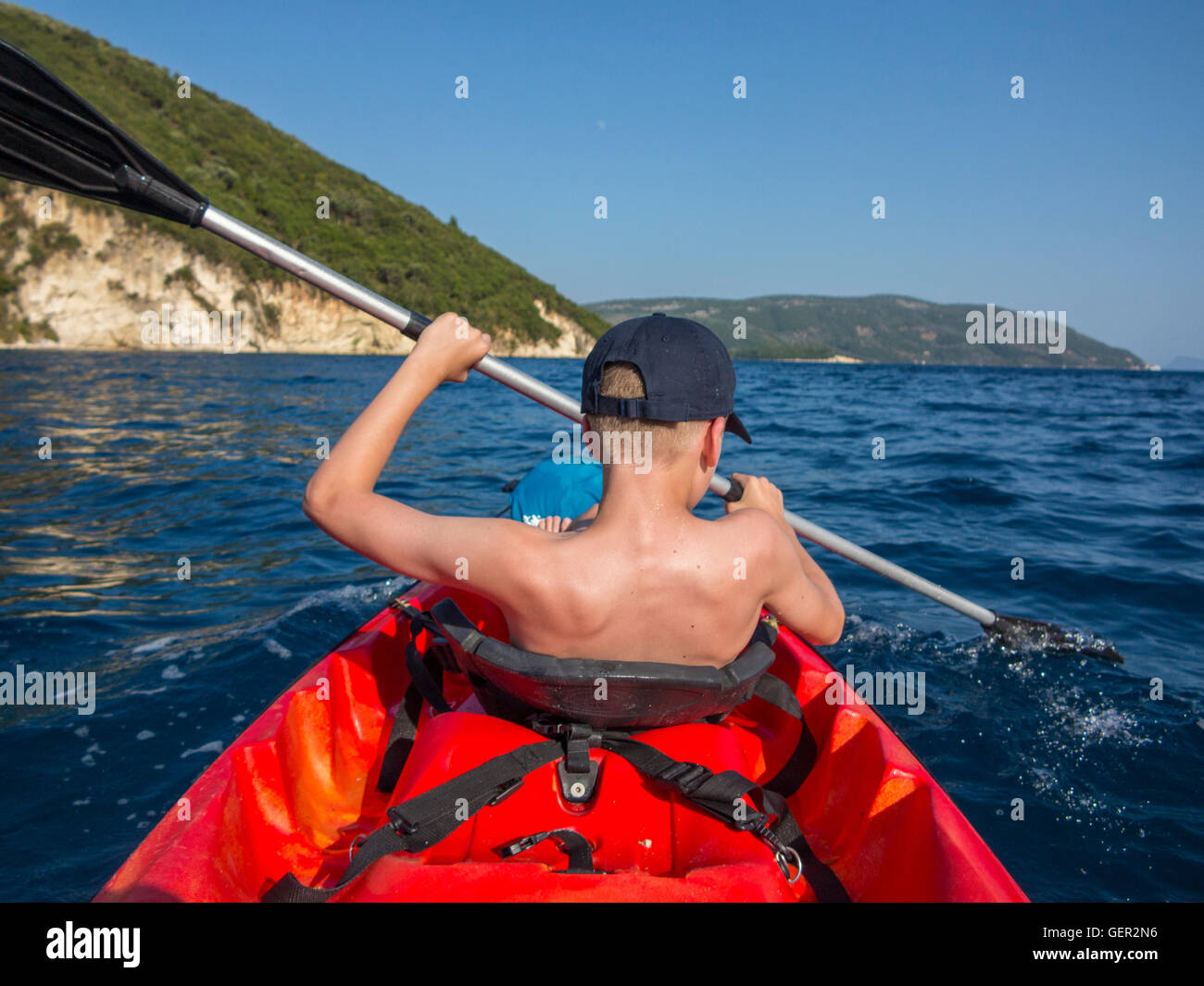 A young boy paddles his canoe on holiday in Greece Stock Photo - Alamy