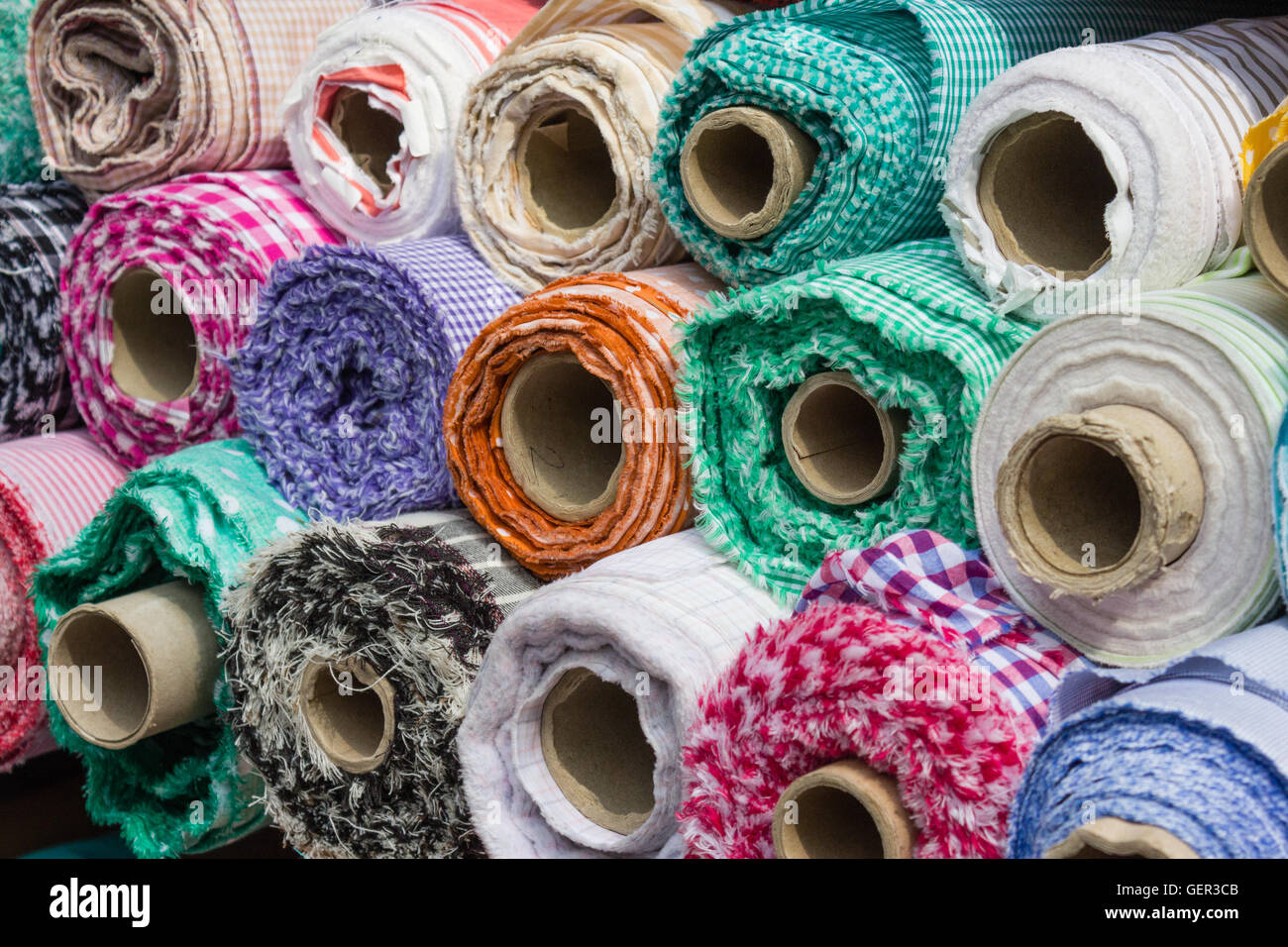 fabric rolls at market stall - textile industry background Stock Photo ...