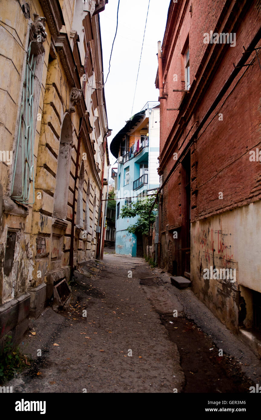 Historic old alleyway with aged walls and rustic buildings in Tbilisi ...