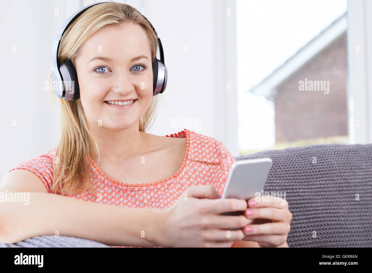 Woman Streams Music From Mobile Phone To Wireless Headphones Stock ...