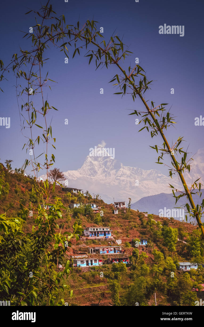 Mount Machhapuchhre and nepalese village on a slope of a mountain ...
