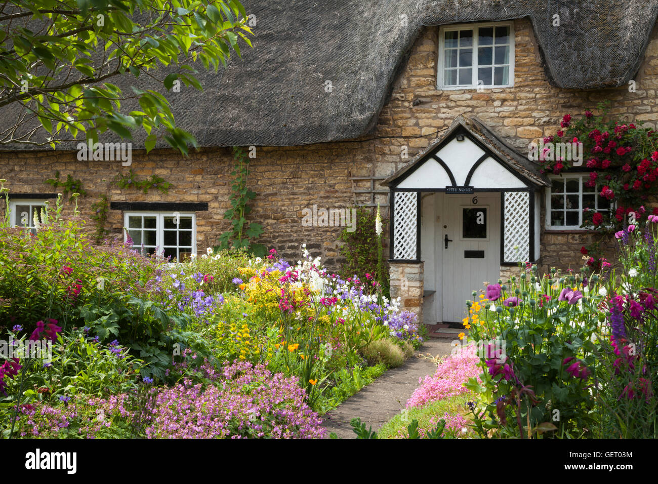 Stone and thatch cottage with colourful garden in Exton Stock Photo - Alamy