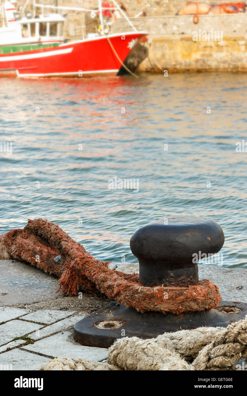 Iron pier in the harbour with a big rope. Vertical image Stock Photo ...