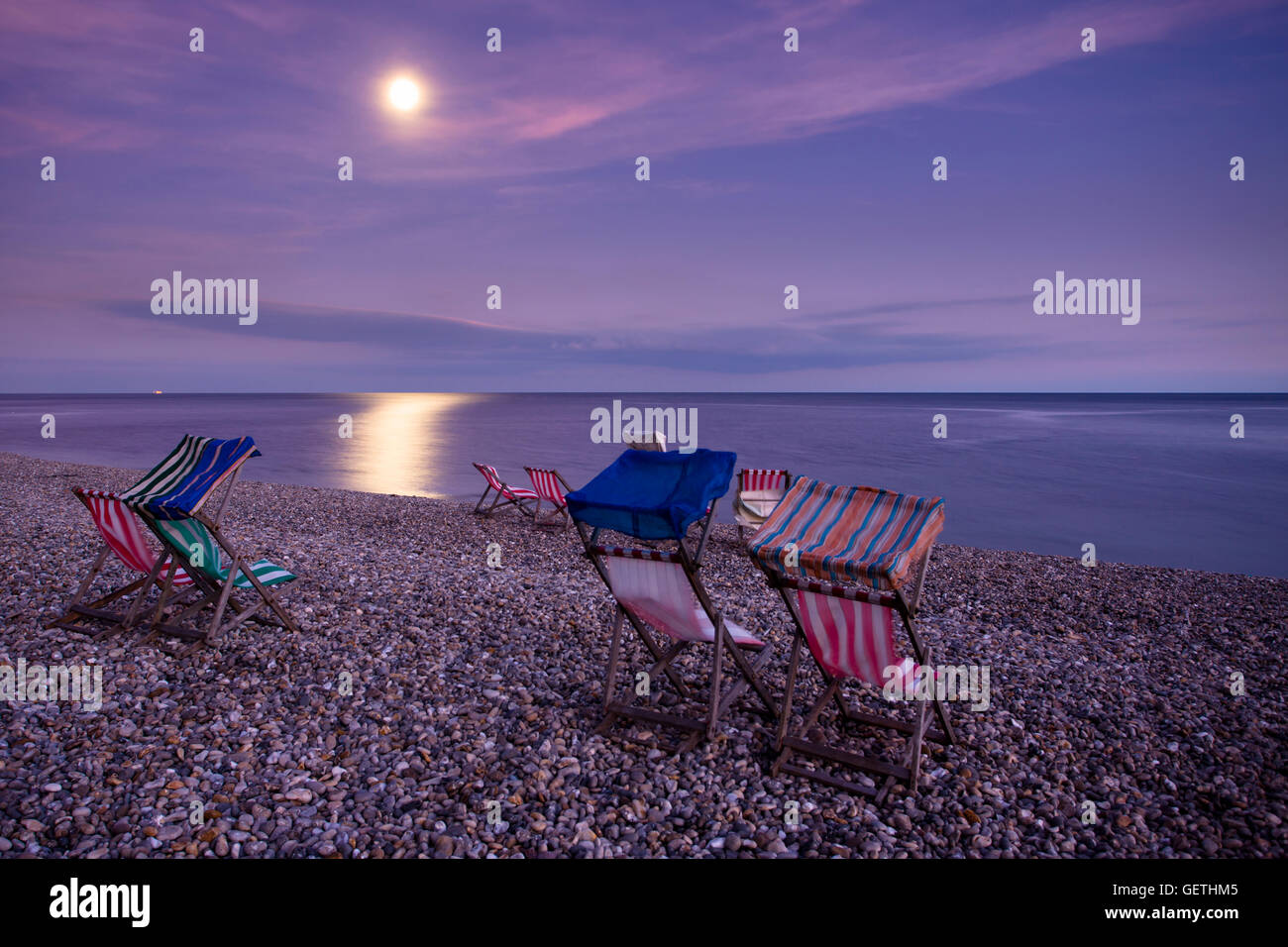 Deck chairs on the beach by moonlight Stock Photo - Alamy