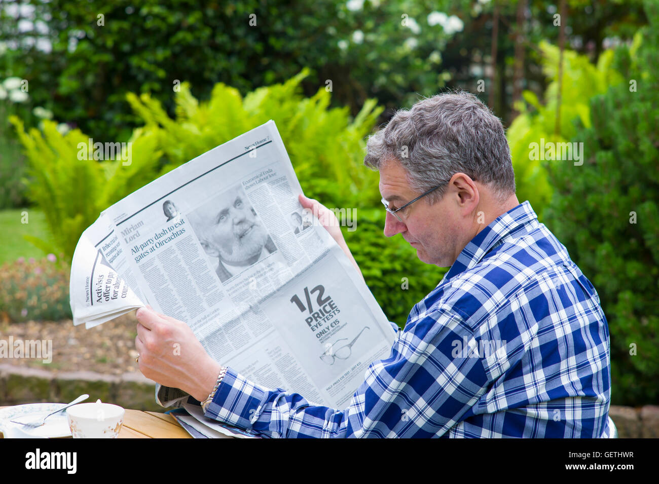 Man reading a paper outdoors Stock Photo - Alamy