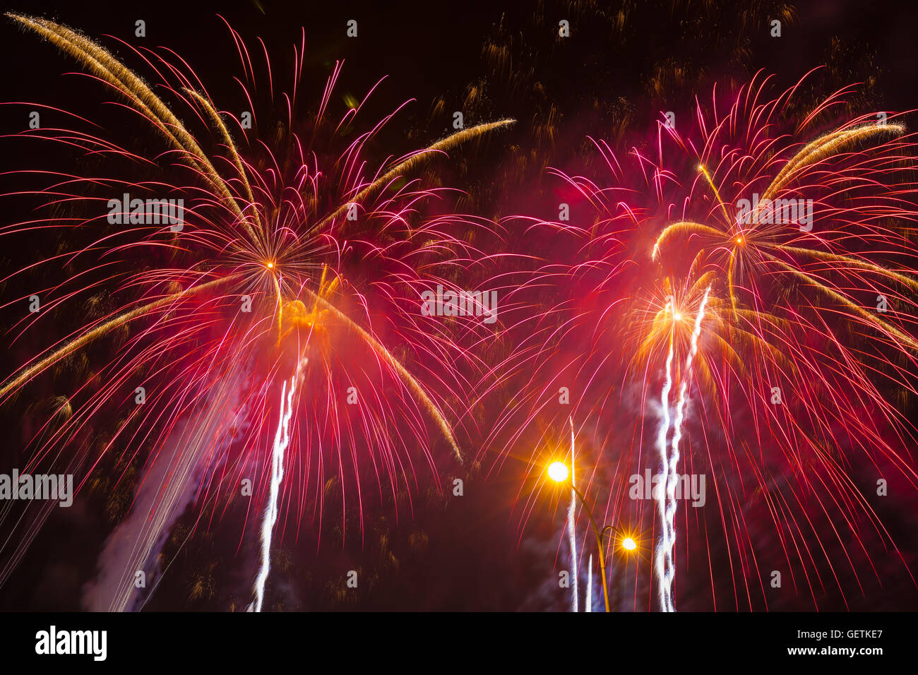 Multiple red orange fireworks with trails Stock Photo - Alamy